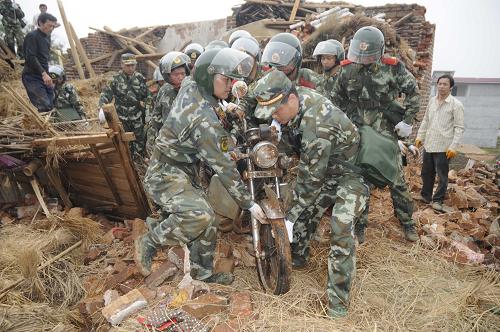 武警官兵帮助灾民抢救物资
